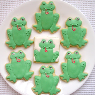 Using piping icing, add a green mouth, pink tongue and dots on the legs.