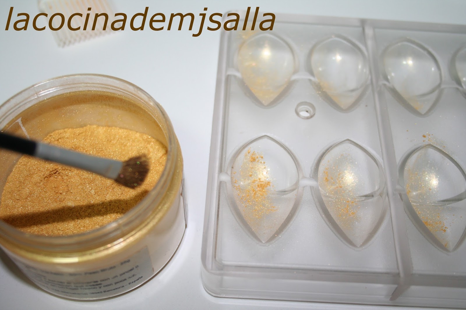 BOMBONES DECORADOS CON ORO Y ROJO BRILLANTES Y RELLENOS DE MOUSSE DE MANGO.