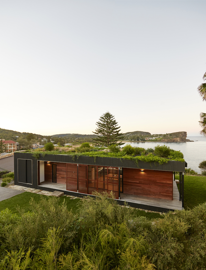 A Green, Prefabricated Home With A Living Room And Water Views ...