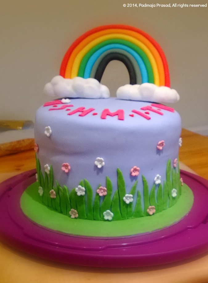 Rainbow cake with colorful layers covered in fondant.