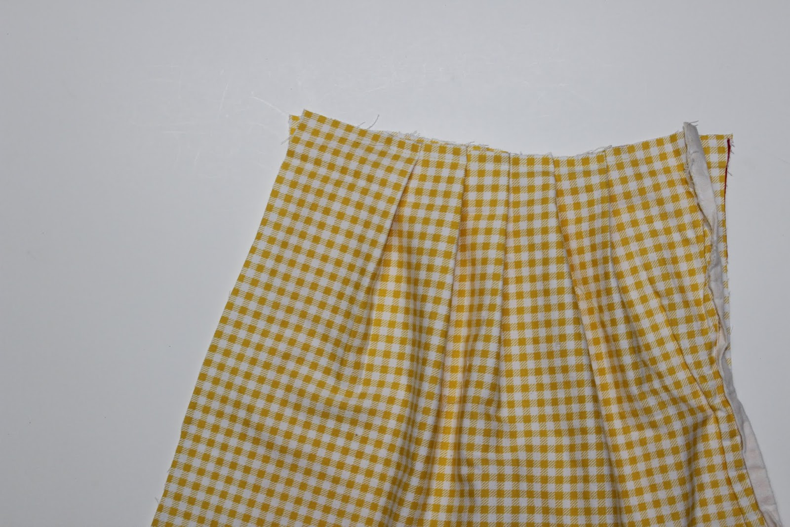 5. Sew wide pleats in the center of the rectangle such that the width ...