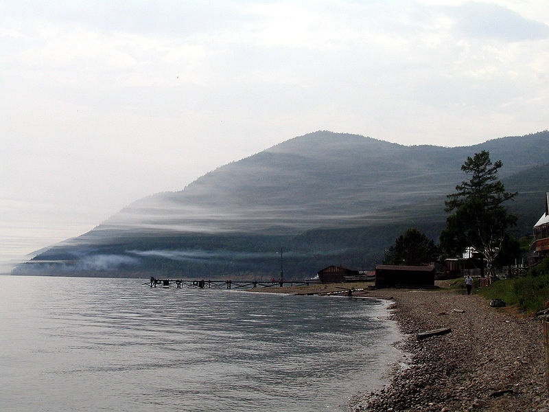 The lake is completely surrounded by rugged mountains and dense forest ...