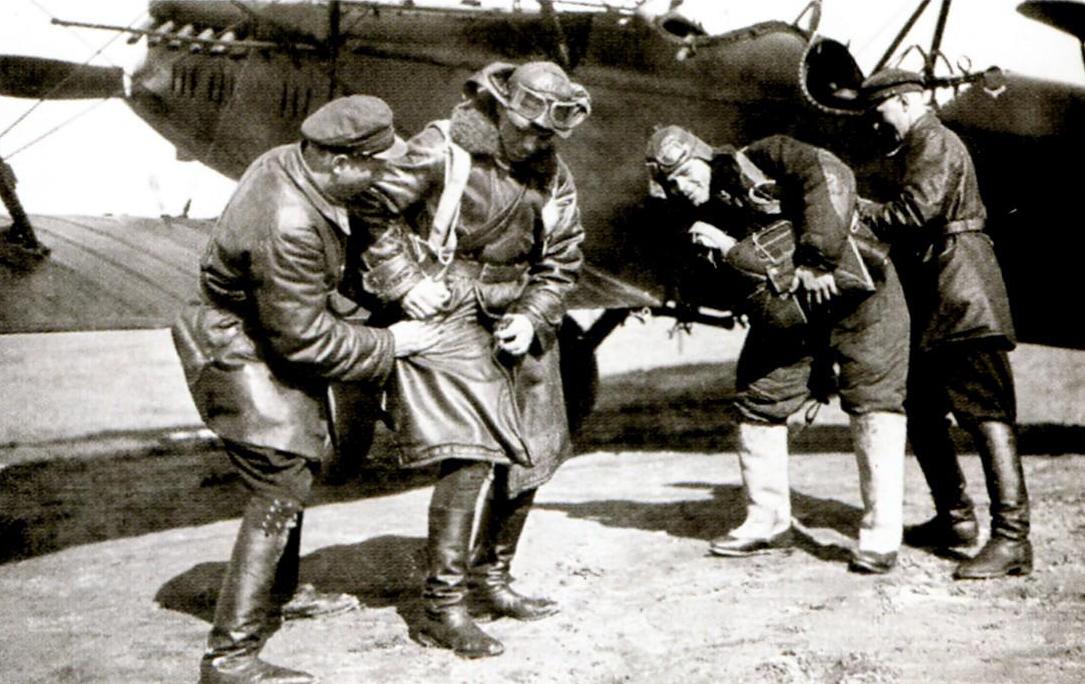 Аэродромные техники помогают экипажу Р-5 надеть и застегнуть парашюты ...