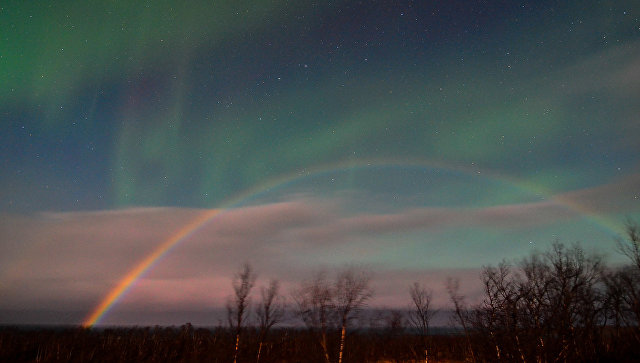 Moonlight rainbow and northern lights in the sky over Sweden