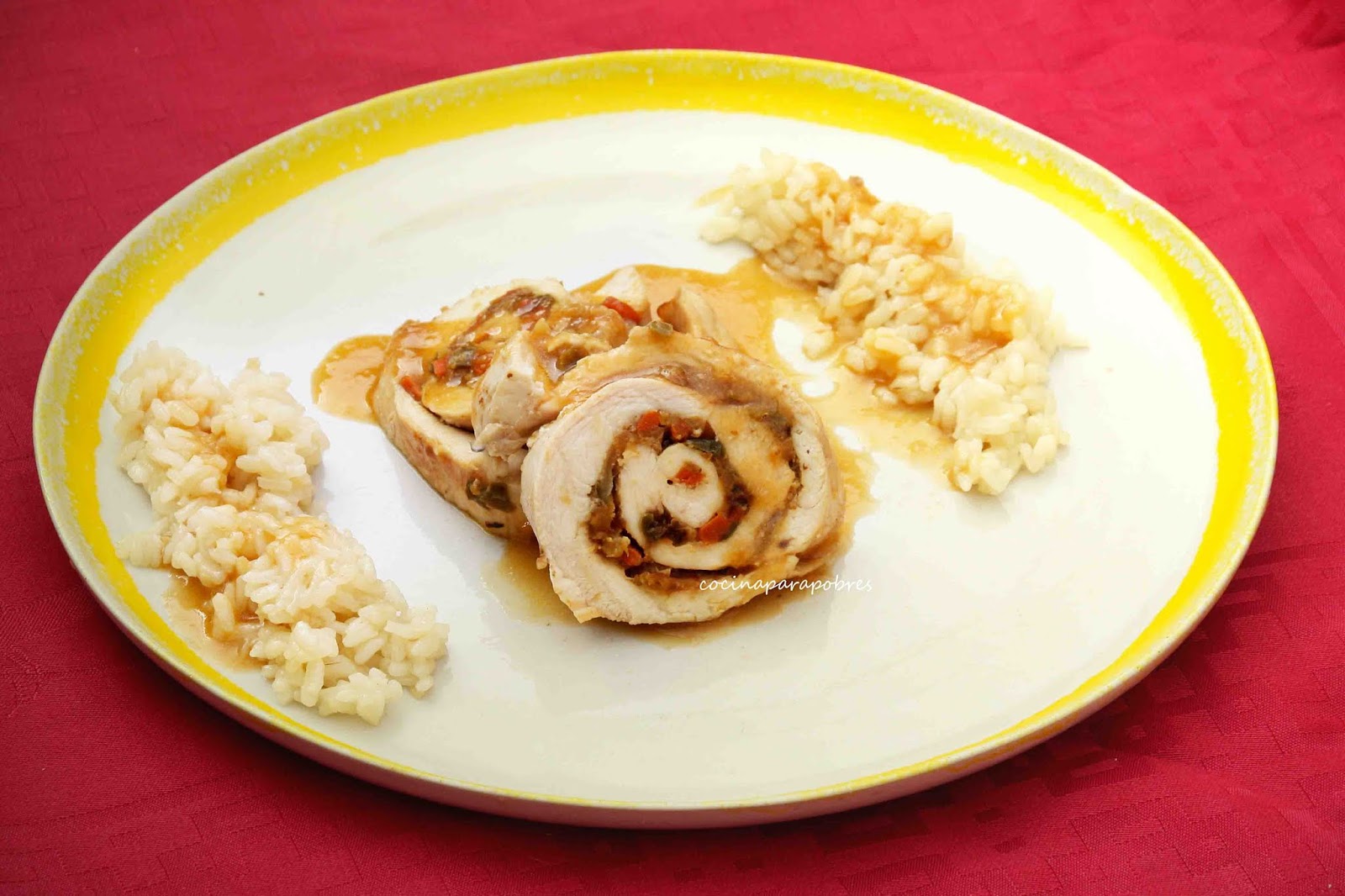 Pechuga de pollo rellena en salsa y acompañada de arroz