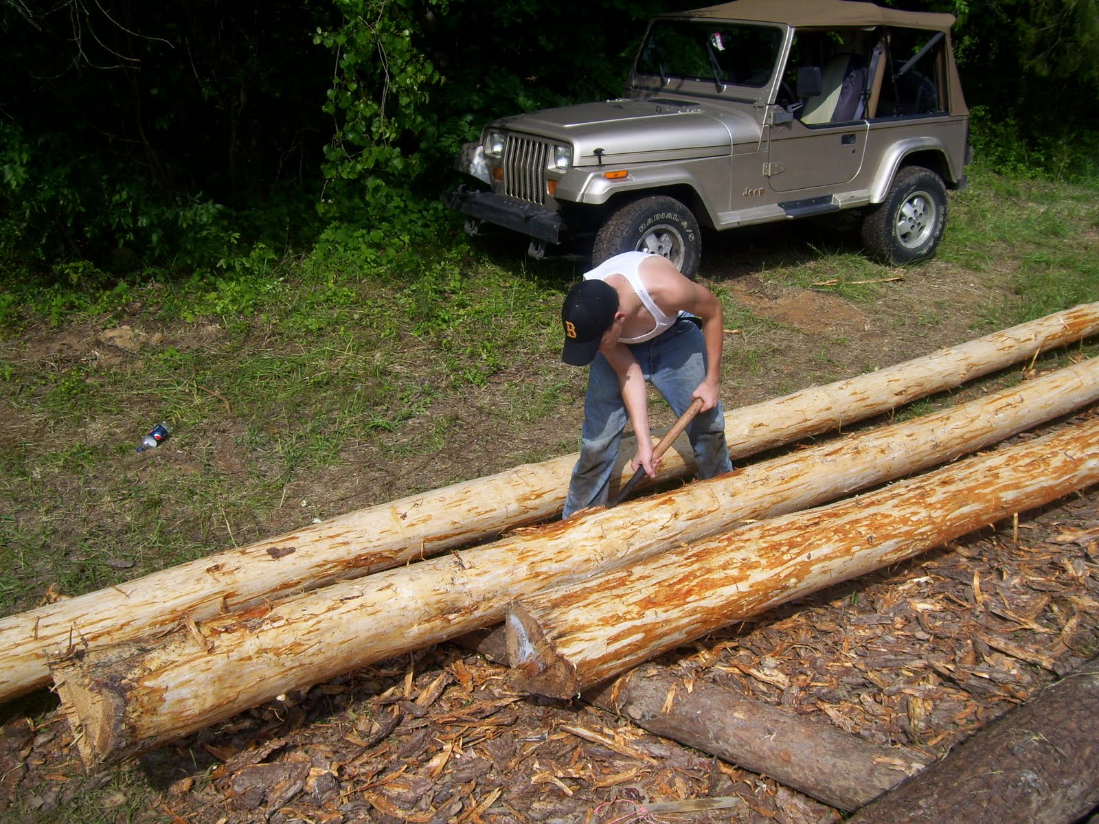 Building a butt and pass log cabin: Peeling some racked logs..finally