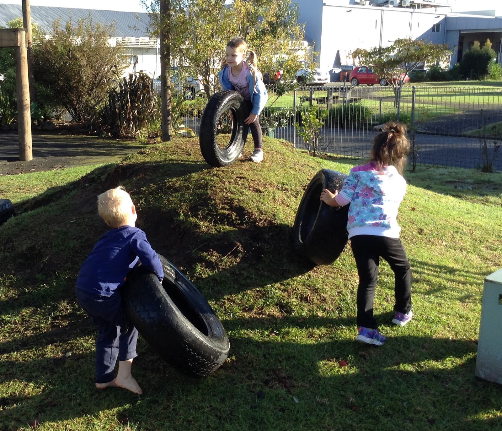 Bream Bay Kindergarten: Playing with tyres.
